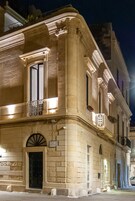 Um edifício histórico com fachada clássica, janelas amplas e entrada imponente.