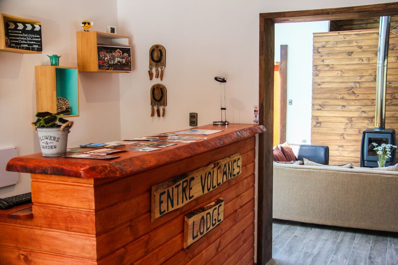 Uma receção de madeira com uma placa a dizer "ENTRE VOLCANES LODGE".
