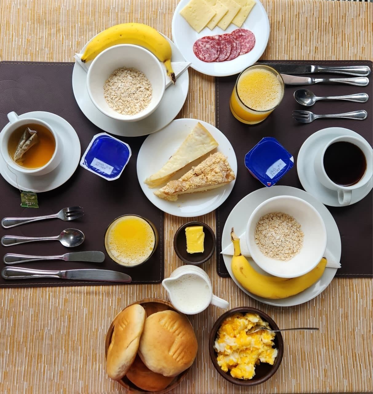 Mesa posta para o café da manhã, com diversos alimentos e utensílios.
