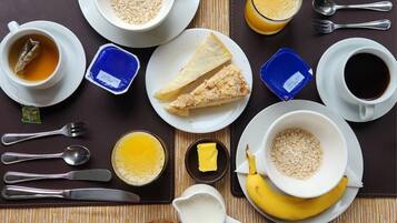 Mesa posta para o café da manhã, com diversos alimentos e utensílios.