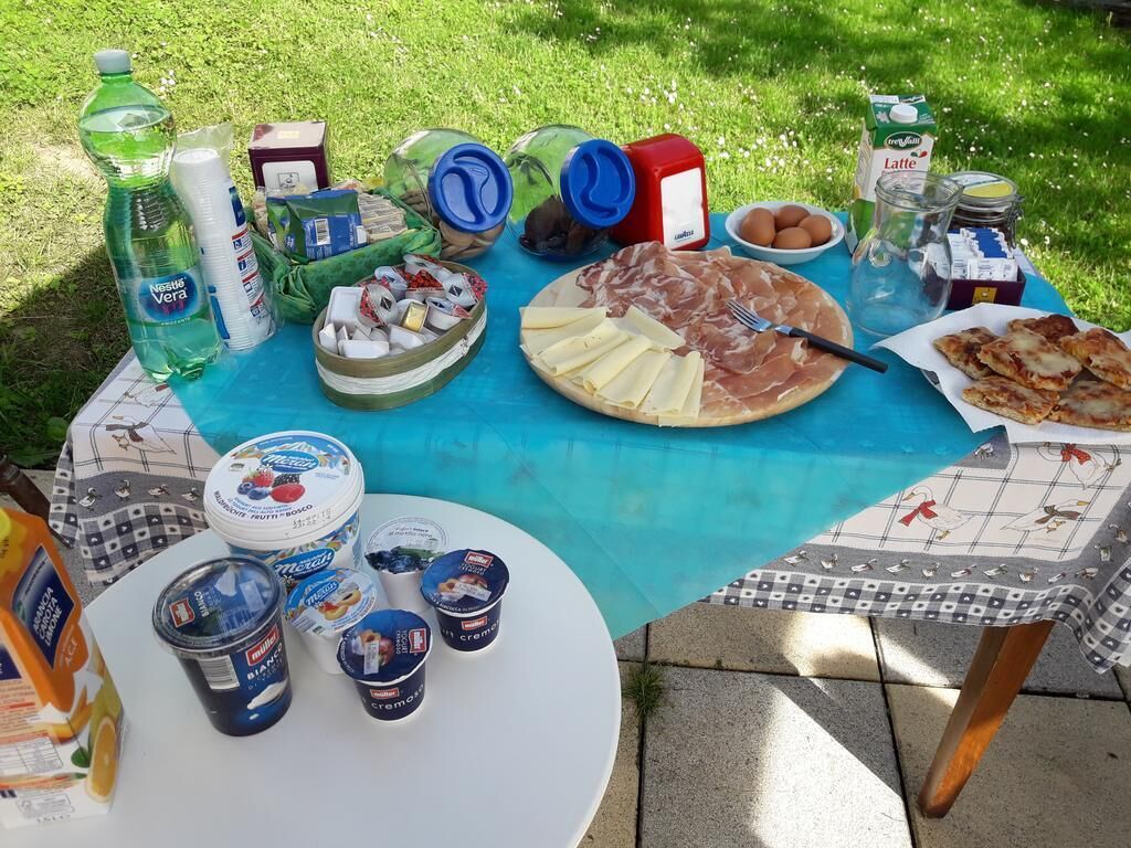Mesa ao ar livre com comida e acompanhamentos para um piquenique.