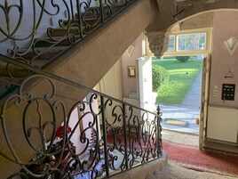 Uma escadaria com grades de metal elaboradas que levam a uma porta.