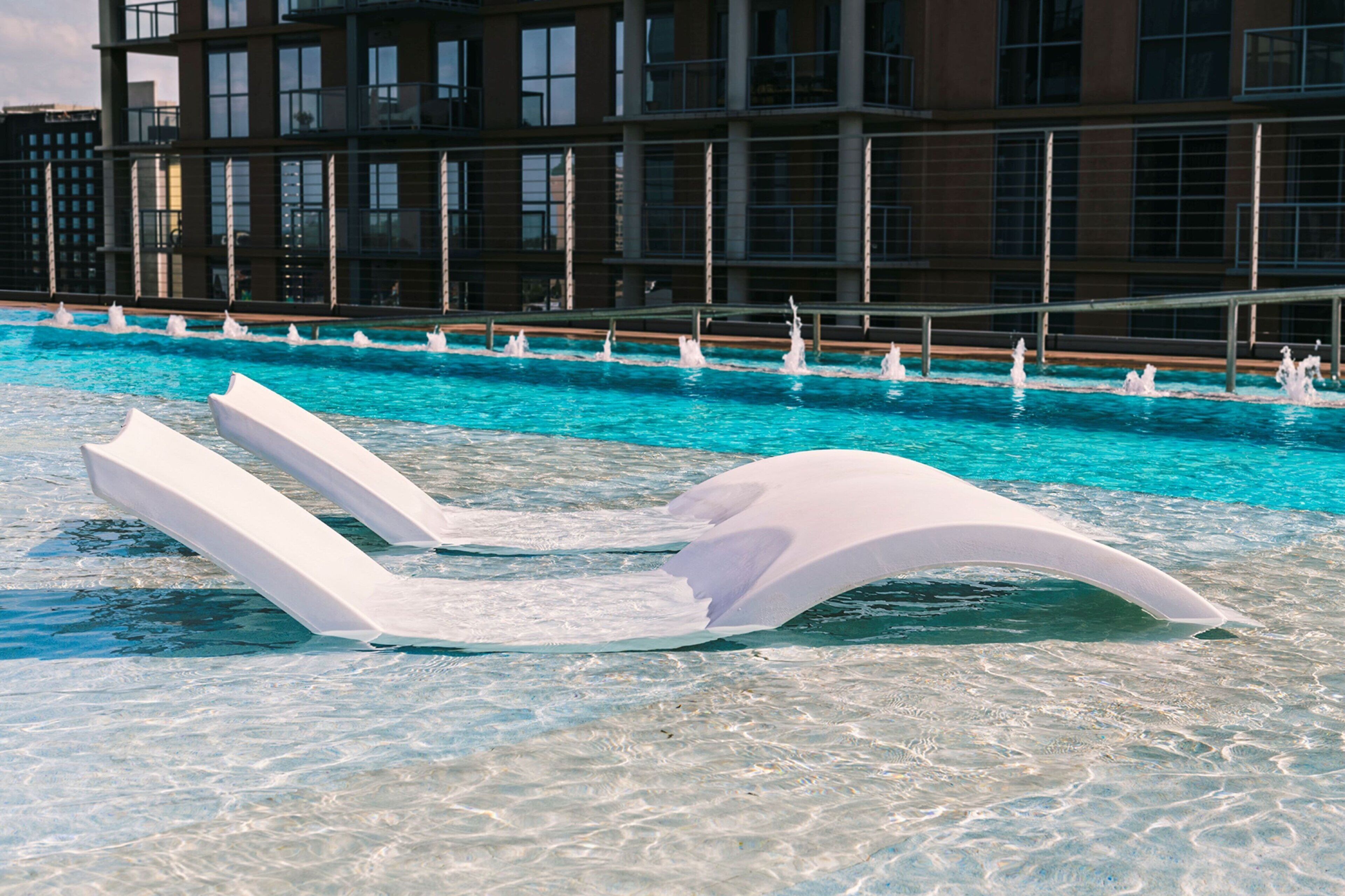 Piscina com água cristalina e uma estrutura branca flutuante.