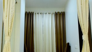 Quarto com duas cadeiras, uma mesa pequena e um armário.