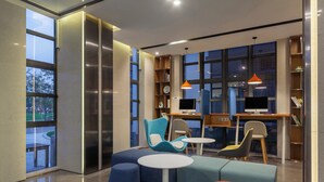 Uma biblioteca moderna com áreas de estar, computadores e estantes de livros.