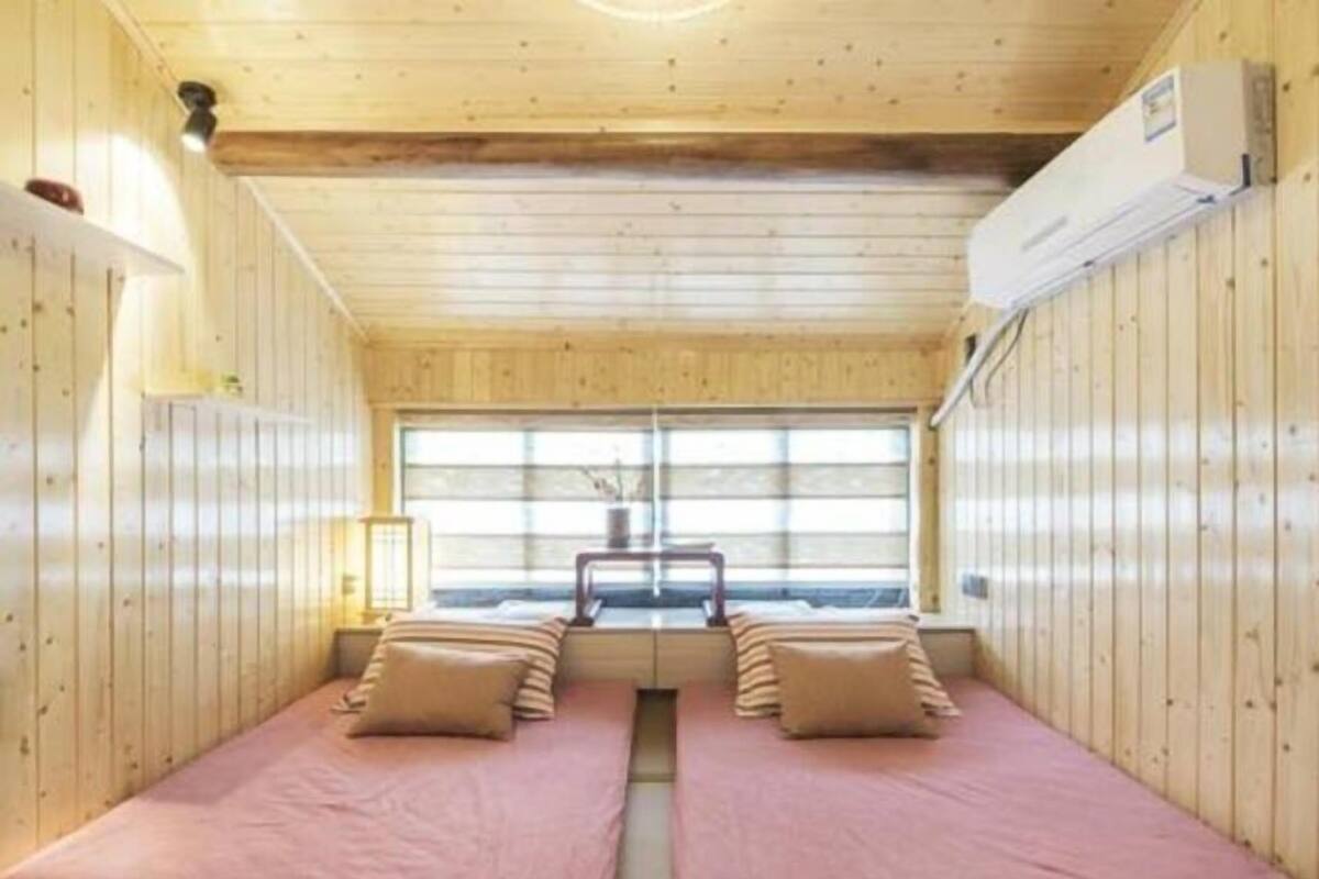 Uma cabana com duas camas, uma janela e paredes de madeira.
