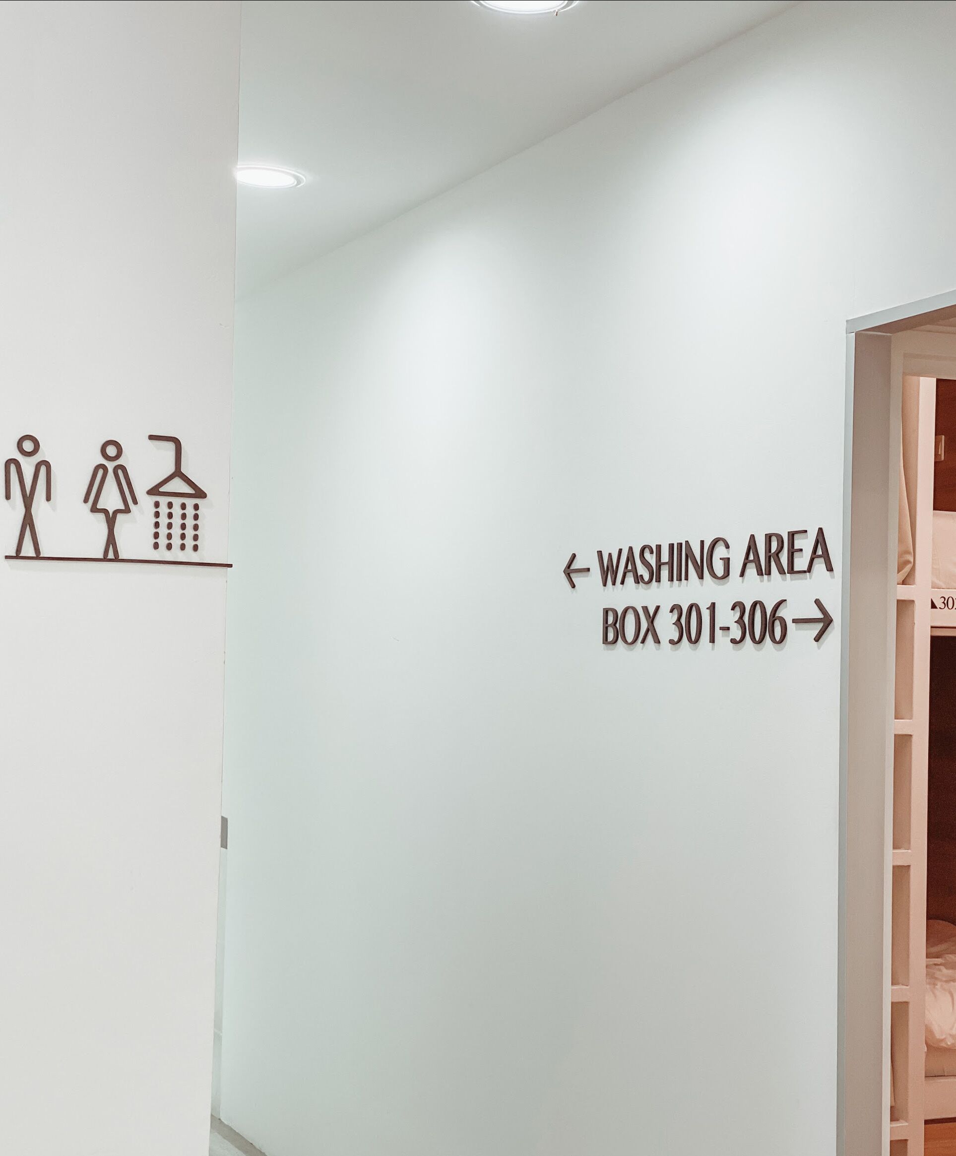 Decoração minimalista com uma placa indicando uma área de lavagem e um número de caixa.