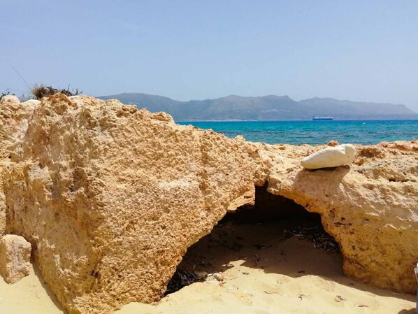 Perto da praia, espreguiçadeiras, guarda-sóis, prática de windsurfe