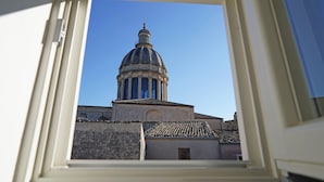 Vista de um edifício com cúpula e colunas vista através de uma janela.