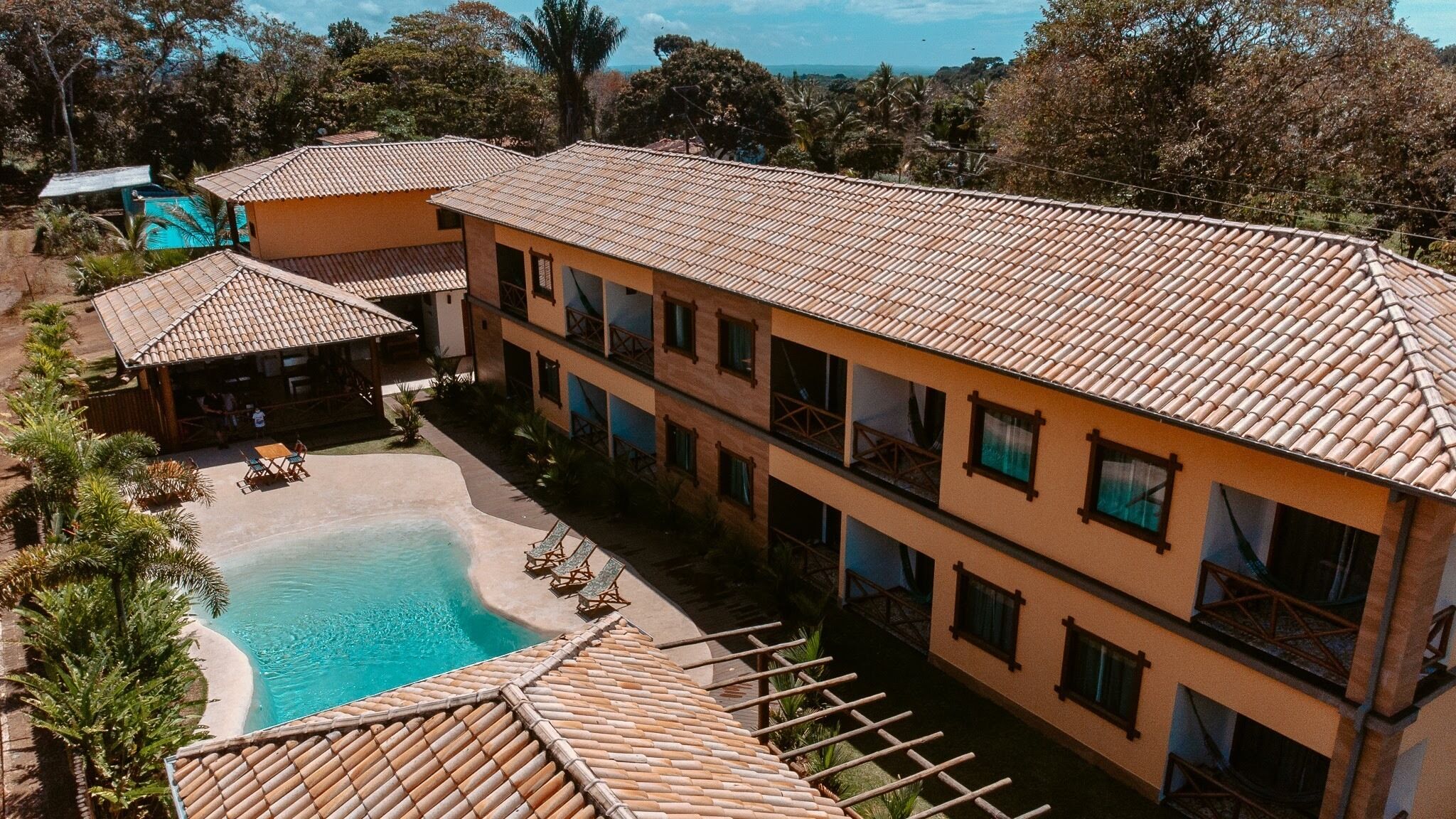 Um resort com piscina, várias varandas e área externa coberta.