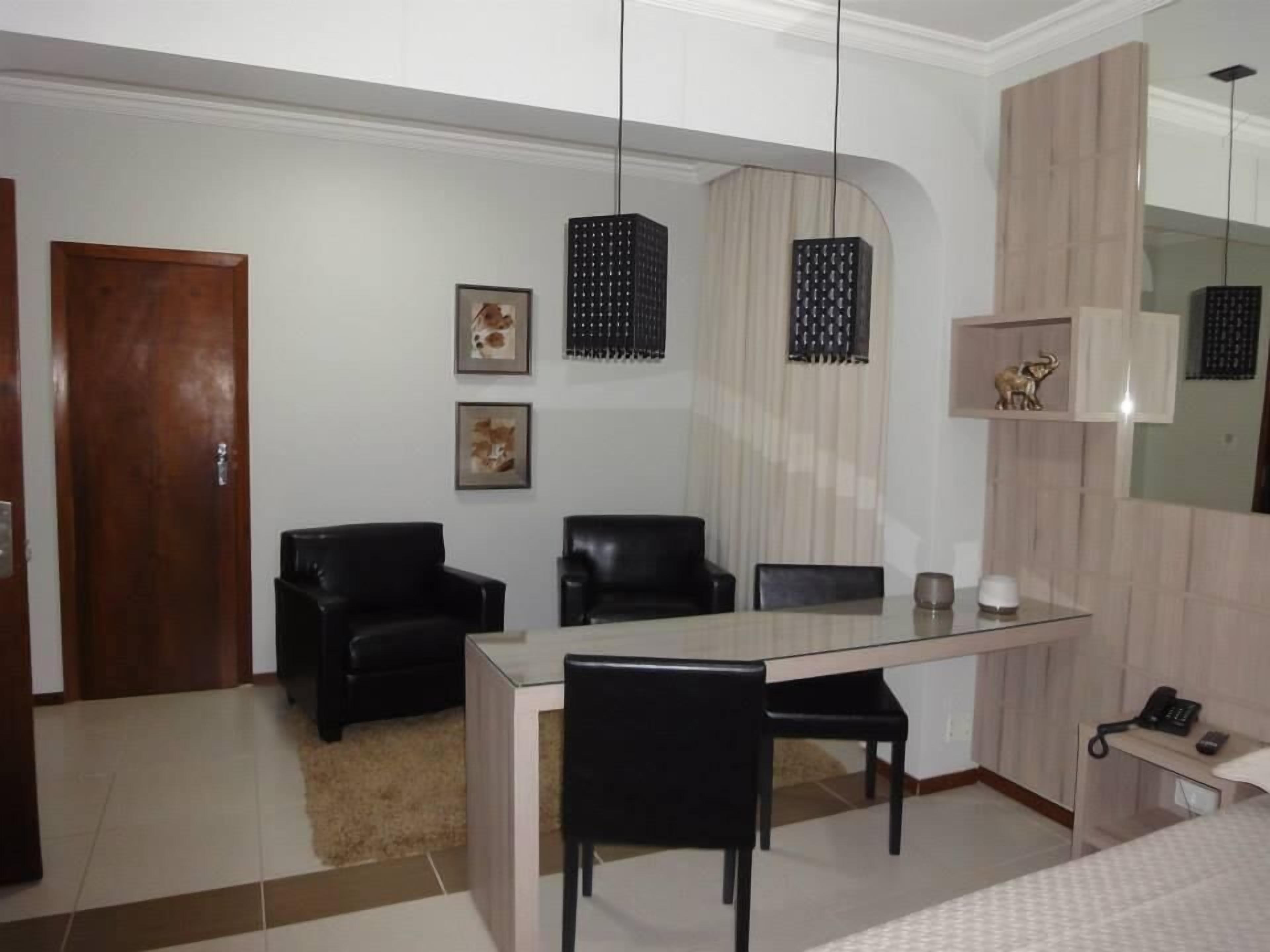 Quarto moderno com cama, escrivaninha e cadeira. Há uma porta e uma janela com cortinas.