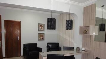 Quarto moderno com cama, escrivaninha e cadeira. Há uma porta e uma janela com cortinas.