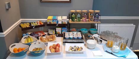 Buffet de café da manhã com diversos alimentos e bebidas.