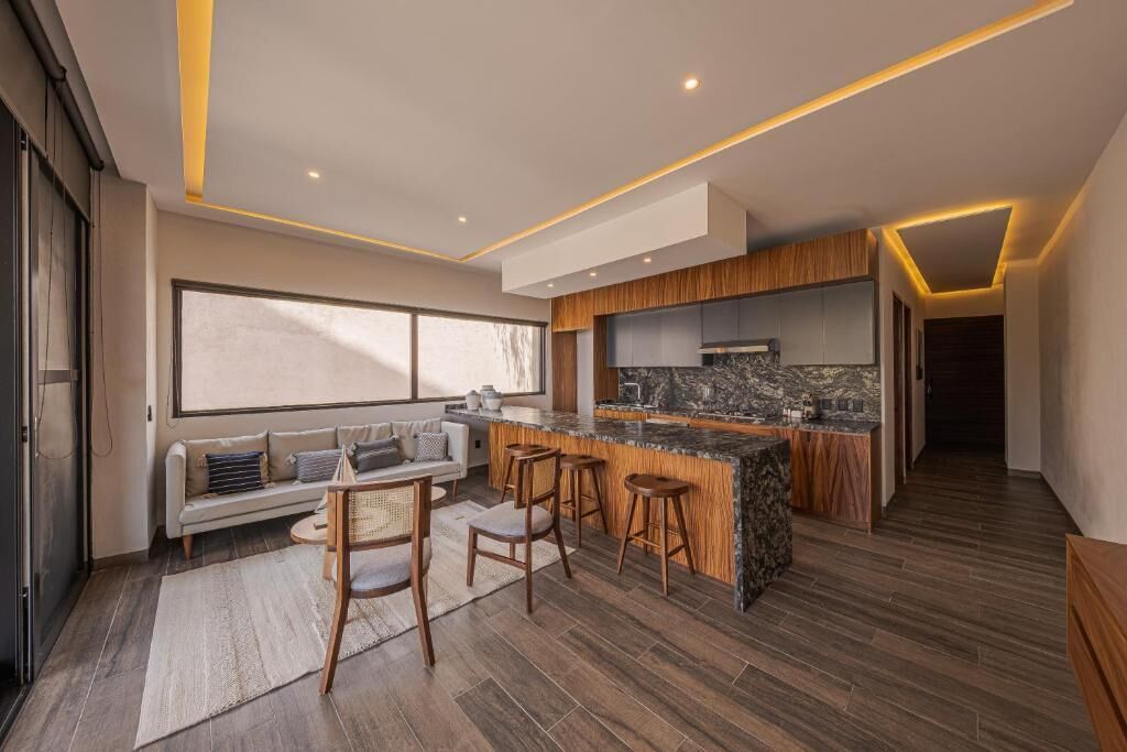 Uma cozinha moderna com bancada de mármore, banquetes de madeira e uma ilha planejada.