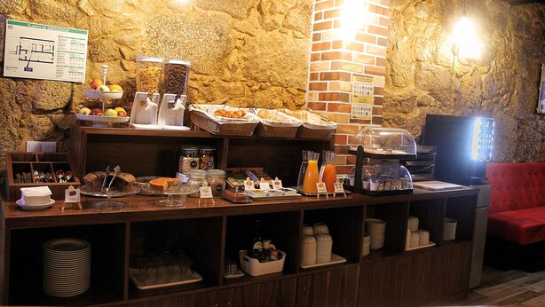Um buffet de café da manhã com diversas opções de comida e um espaço para café.
