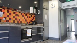 Uma cozinha moderna com micro-ondas, forno e um relógio na parede.