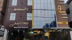 Um edifício de vários andares com a sinalização 'AAccord Capitalo' e 'AAccord Multi Cuisine Restaurant'.