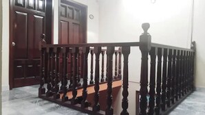 Corrimão de madeira com chão de mármore.
