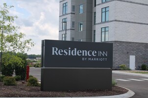 Placa indicando um hotel Residence Inn by Marriott, com fachada de tijolos moderna e diversas janelas.