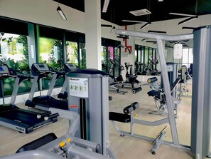 Academia com esteiras, máquinas de peso e equipamentos de ginástica.