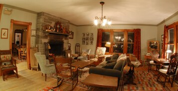 Uma sala de estar aconchegante com lareira, móveis de madeira e um candelabro.