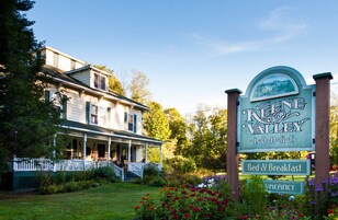 Placa para a Keene Valley Lodge com varanda e jardim.