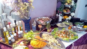 Uma mesa de buffet com diversos alimentos e acompanhamentos.