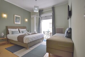 Quarto com cama, sofá, mesa pequena e cadeira.