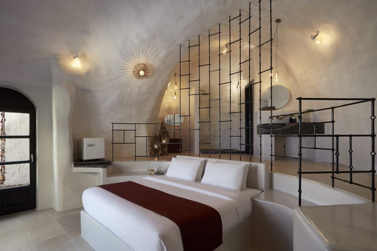 Um quarto moderno com uma cama grande, uma escrivaninha e um design de teto único.