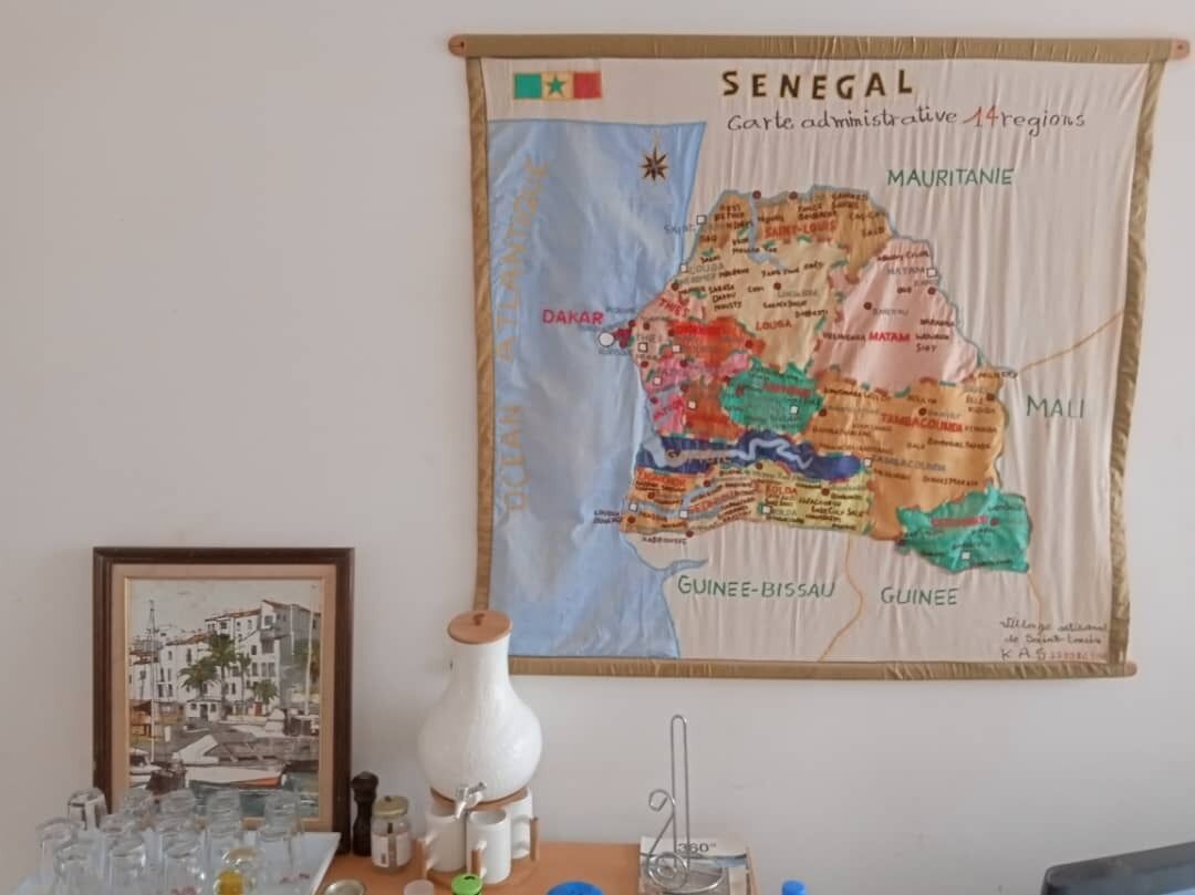 Um mapa de parede do Senegal com as regiões administrativas assinaladas.