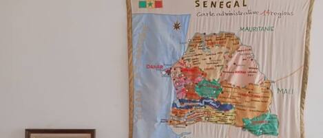 Um mapa de parede do Senegal com as regiões administrativas assinaladas.