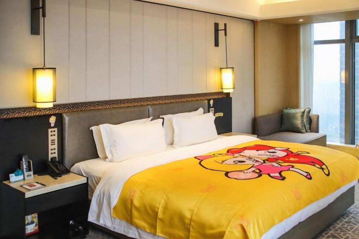 Quarto de hotel com cama, mesas de cabeceira, luminária e janela.