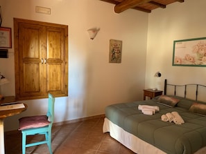 Quarto com cama, cadeira, escrivaninha e guarda-roupa de madeira.