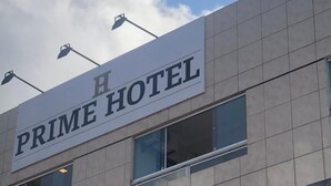 Um edifício com uma placa na fachada que diz 'H PRIME HOTEL'.