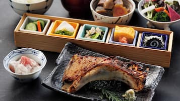 Uma refeição tradicional japonesa com diversos pratos, incluindo arroz, sopa e sashimi.