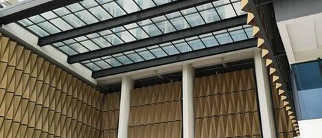 Um edifício moderno com entrada de vidro e fachada estampada.
