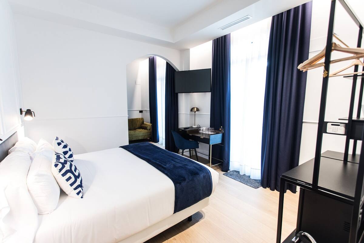 Quarto de hotel moderno com cama, escrivaninha e cadeira.
