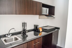 Minifrigorífico, um micro-ondas, utensílios de cozinha 