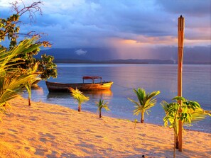 Praia particular, areia branca, espreguiçadeiras, guarda-sóis 