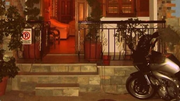Exterior de um edifício chamado 'EVANS' com uma motocicleta estacionada na frente.