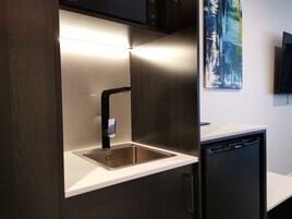 Uma máquina de café expresso, uma cafeteira/bule, Minifrigorífico