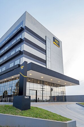 Um edifício moderno de hotel com uma placa chamativa 'Slim', grandes janelas e um telhado plano.