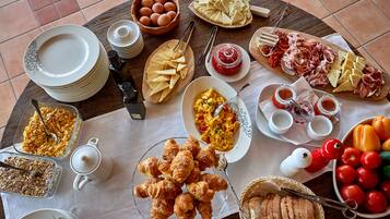 Buffet de café da manhã com diversos alimentos e utensílios.