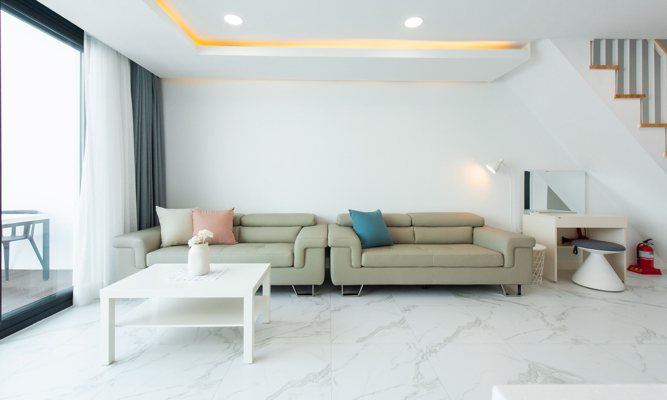 Uma sala de estar moderna com um sofá, uma mesa de centro e uma pequena mesa lateral.