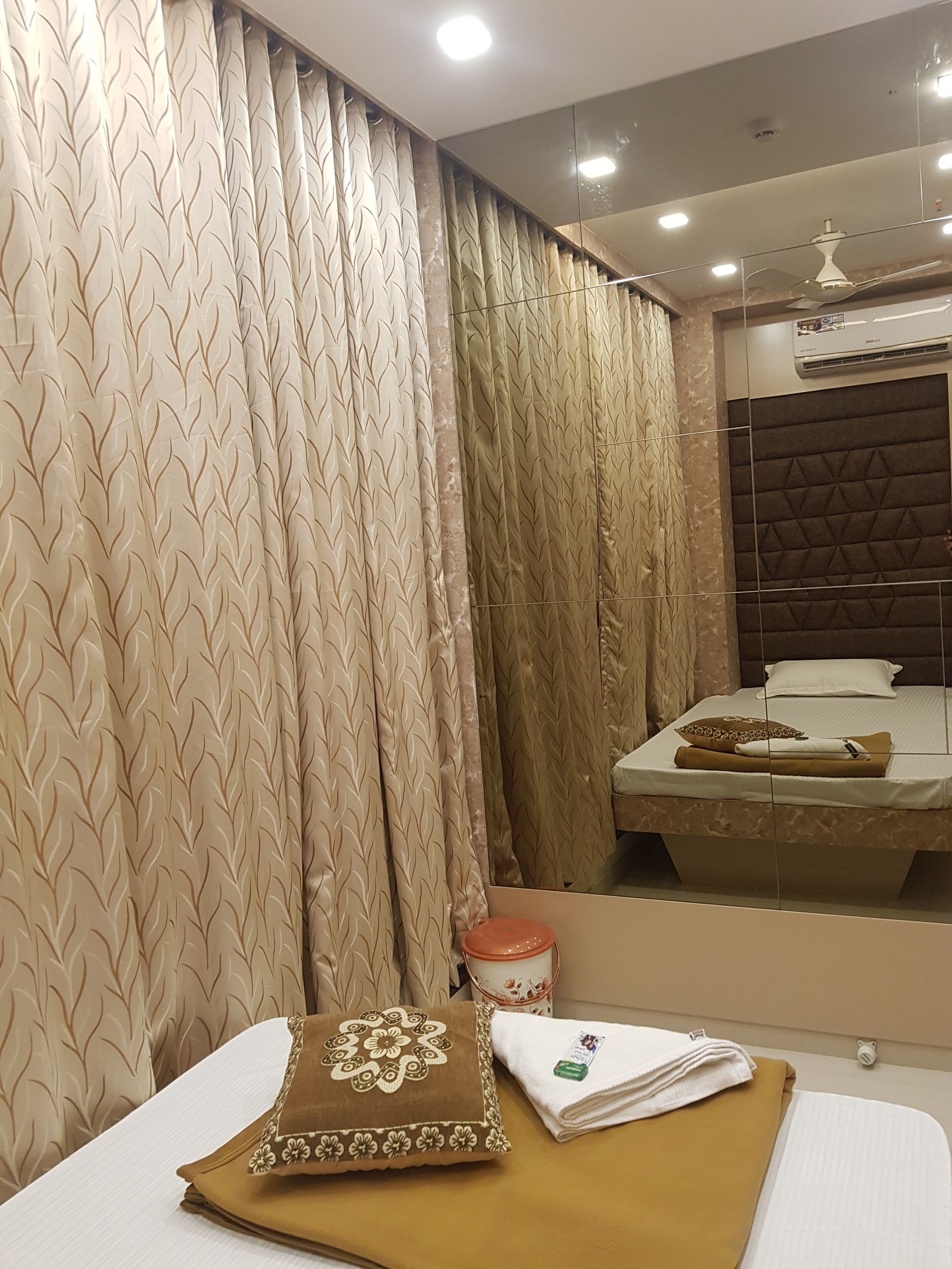 Quarto de hotel com cama, espelho e janela com cortinas.