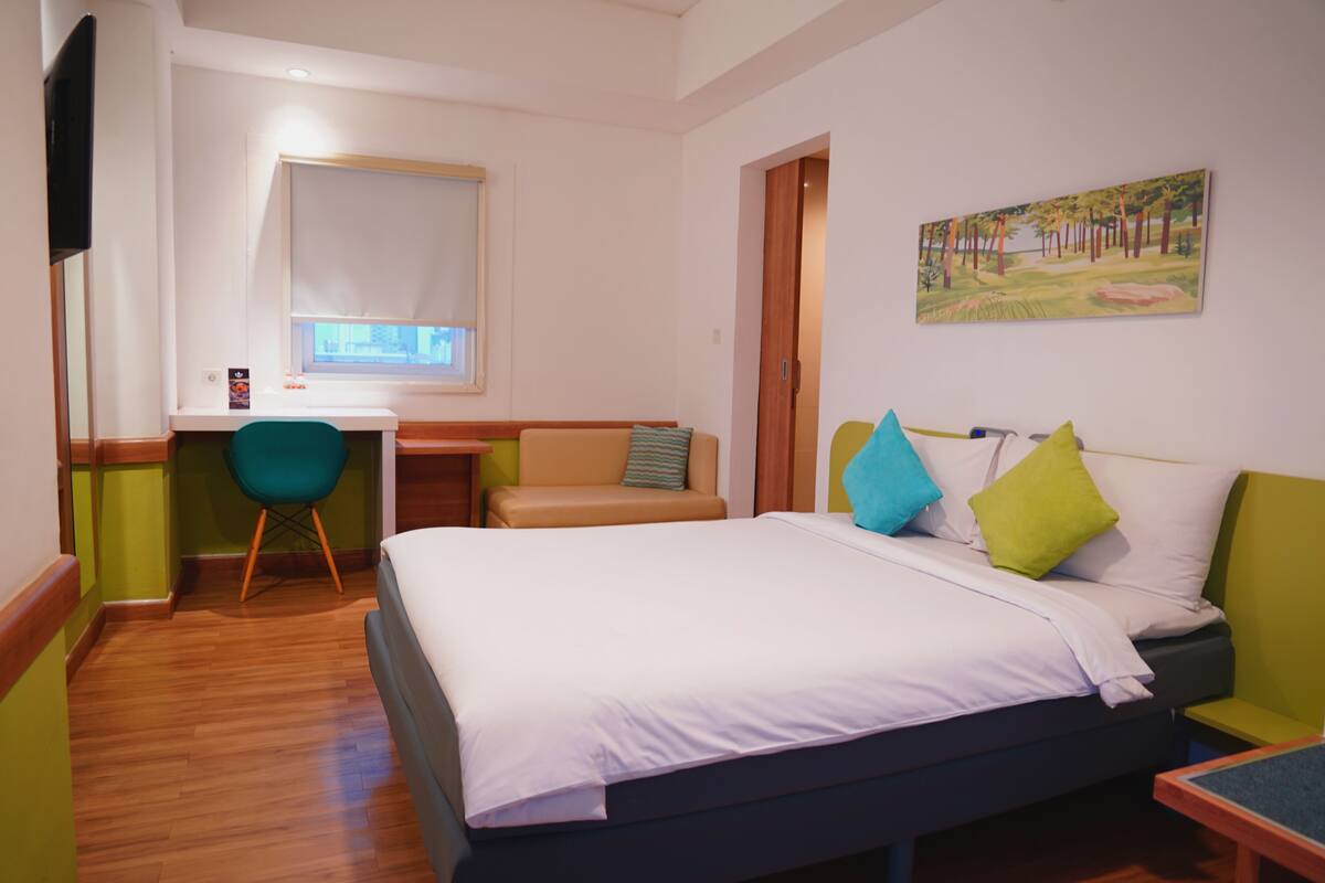 Quarto com cama, escrivaninha e cadeira.