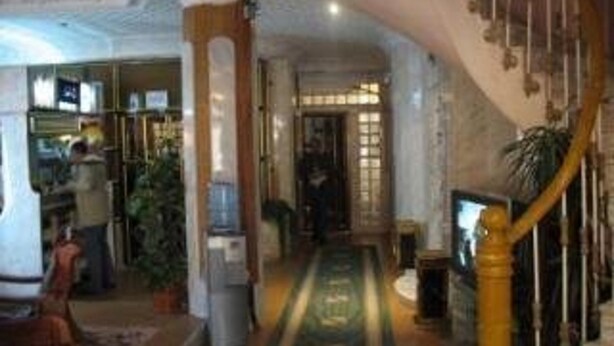 Um hall imponente com escadaria de madeira, um longo corredor e uma grande janela.