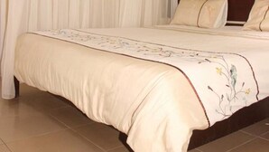 Quarto de hotel com cama, cortinas e cabeceira.