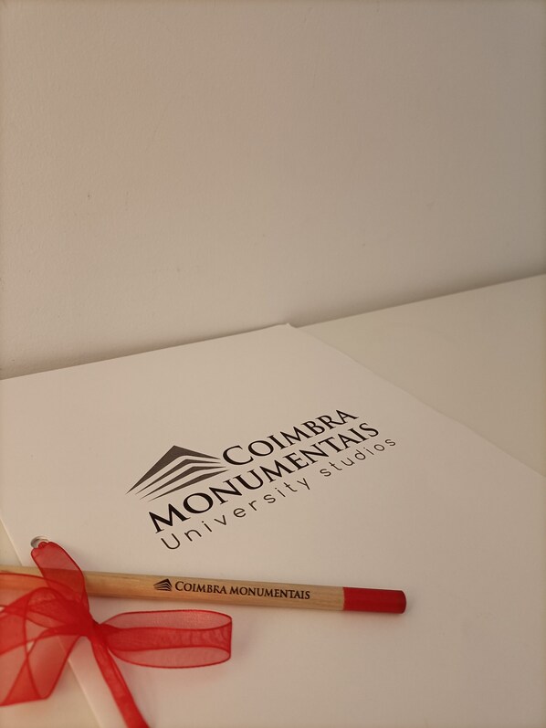 Um certificado branco com o logotipo e o nome 'COIMBRA MONUMENTAIS' e 'Estudos Universitários' impressos.