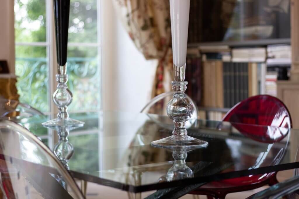 Uma mesa de vidro com um objeto vermelho e um objeto de vidro transparente.